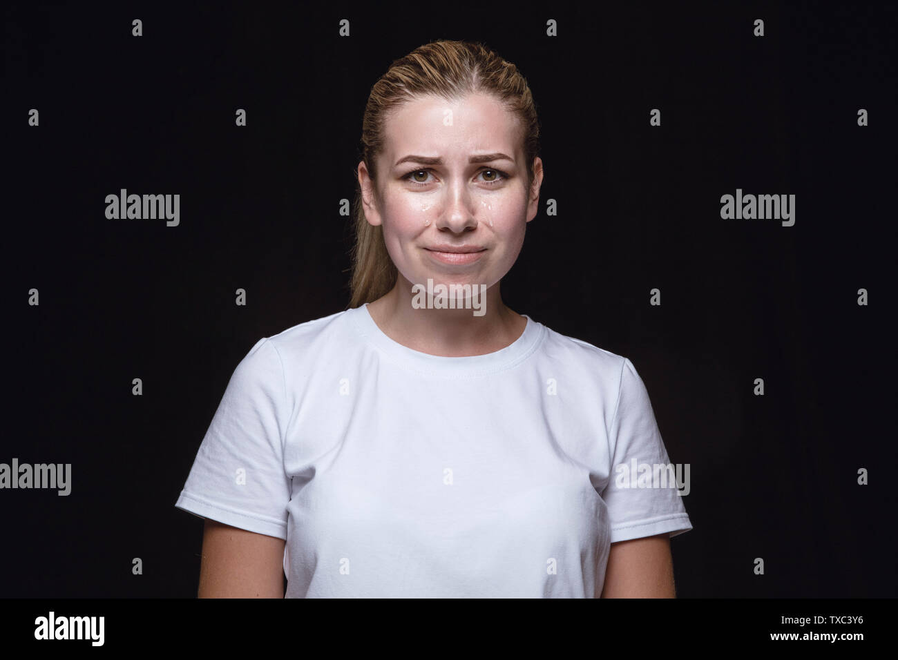 Close up portrait of young woman isolated on black studio background ...