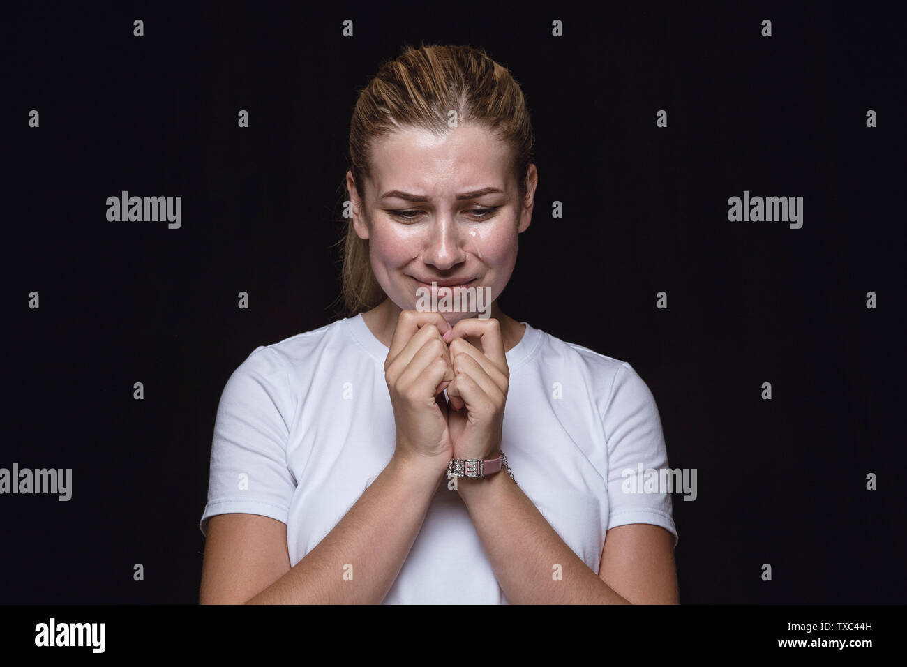 Close up portrait of young woman isolated on black studio background ...