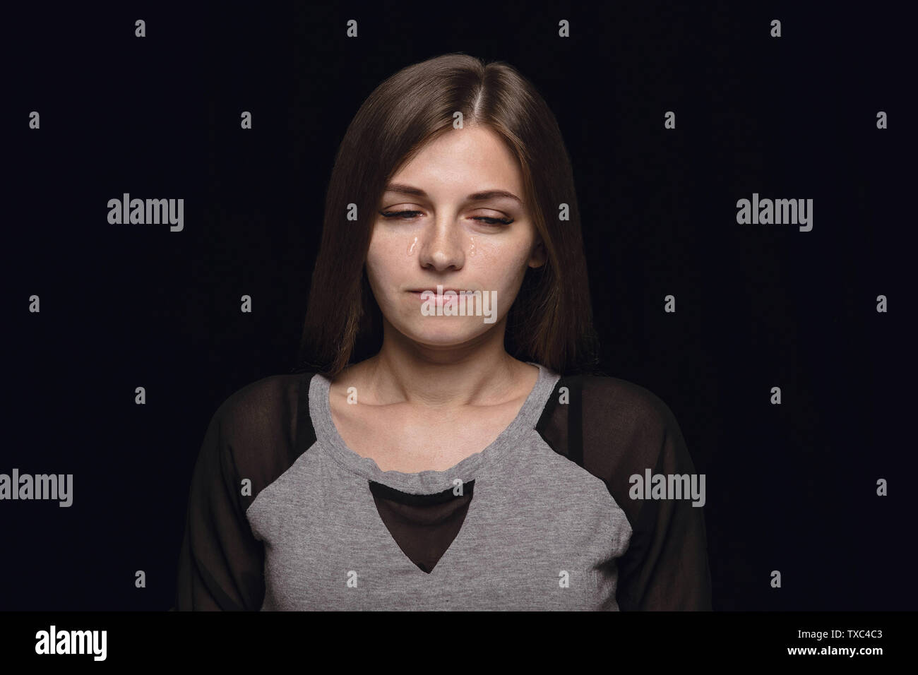 Close up portrait of young woman isolated on black studio background ...