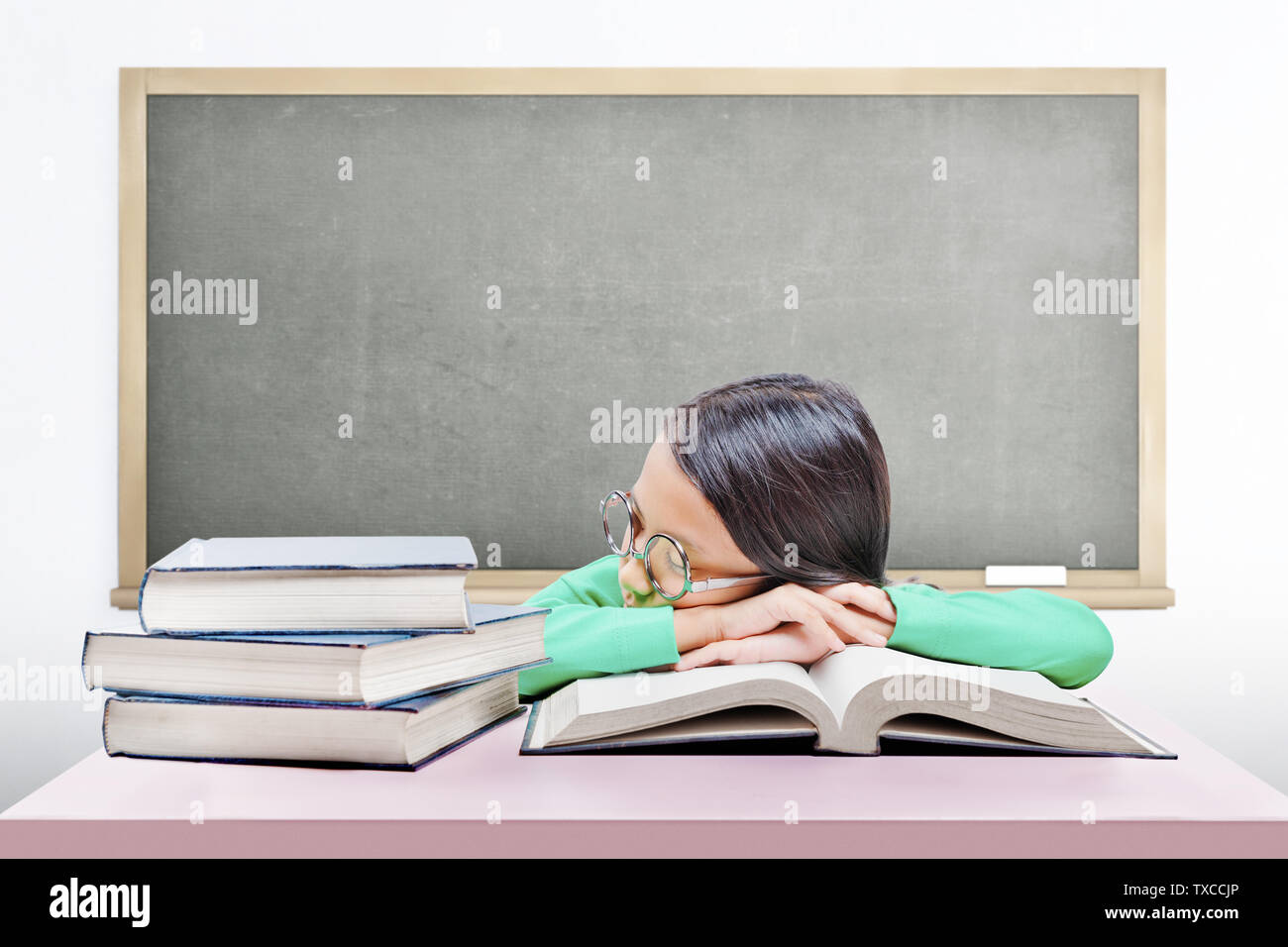 Asian cute girl with glasses fall asleep on book on the desk with ...