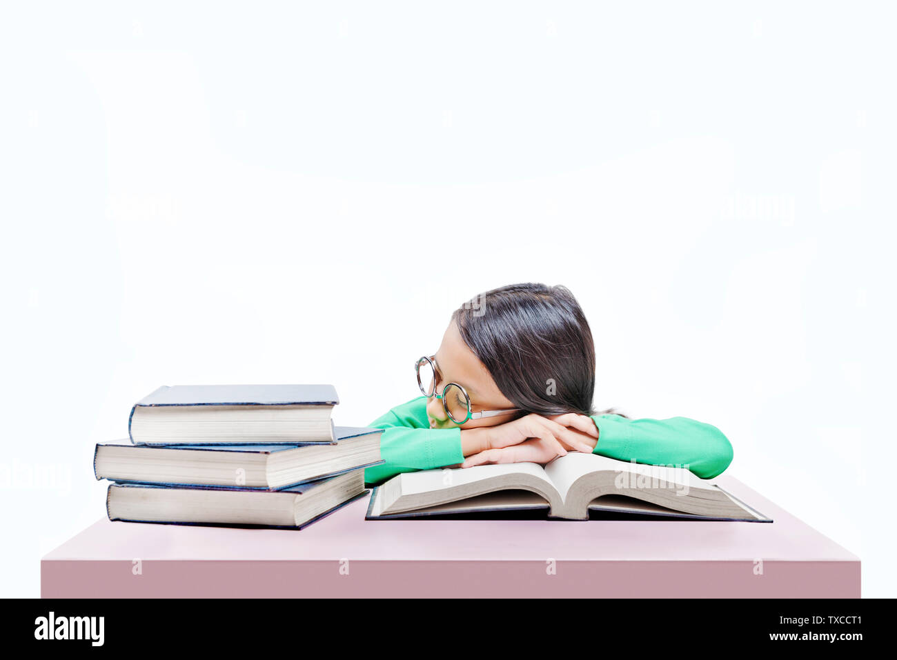Asian cute girl with glasses fall asleep on book on the desk isolated ...