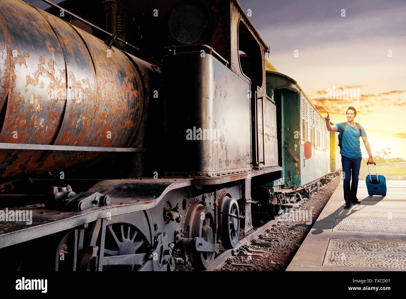 Asian man with suitcase bag and backpack standing and pointing a steam ...