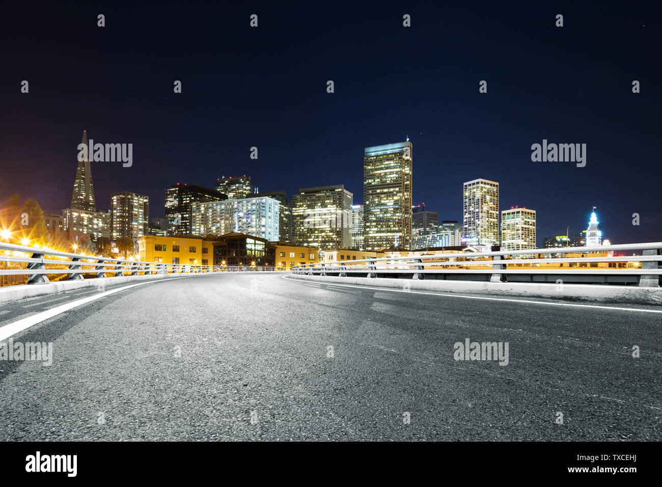 Empty road with modern city at night Stock Photo - Alamy