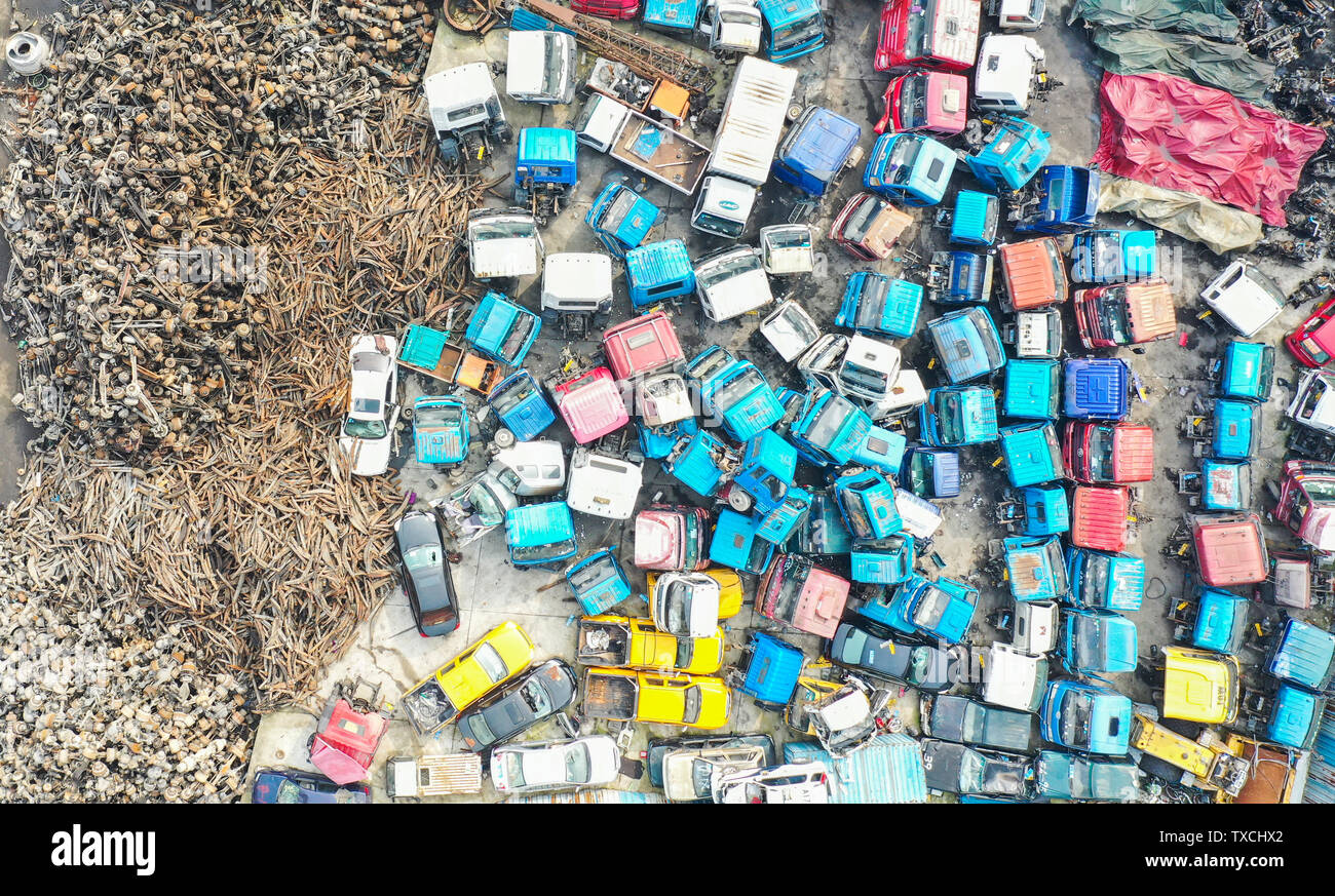 Piled together, scrap-out old motor vehicles waiting to be dismantled ...