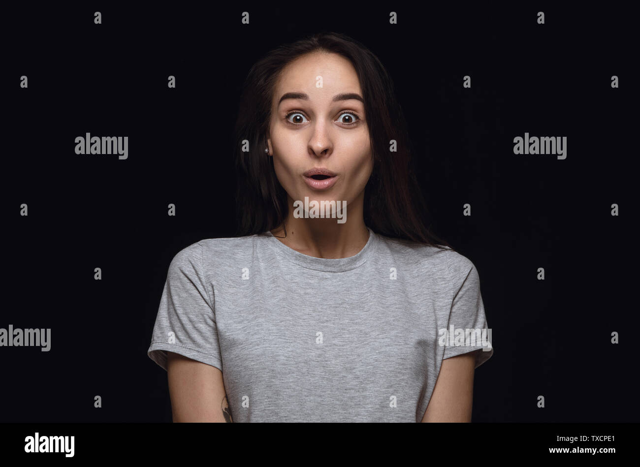 Close up portrait of young woman isolated on black studio background ...