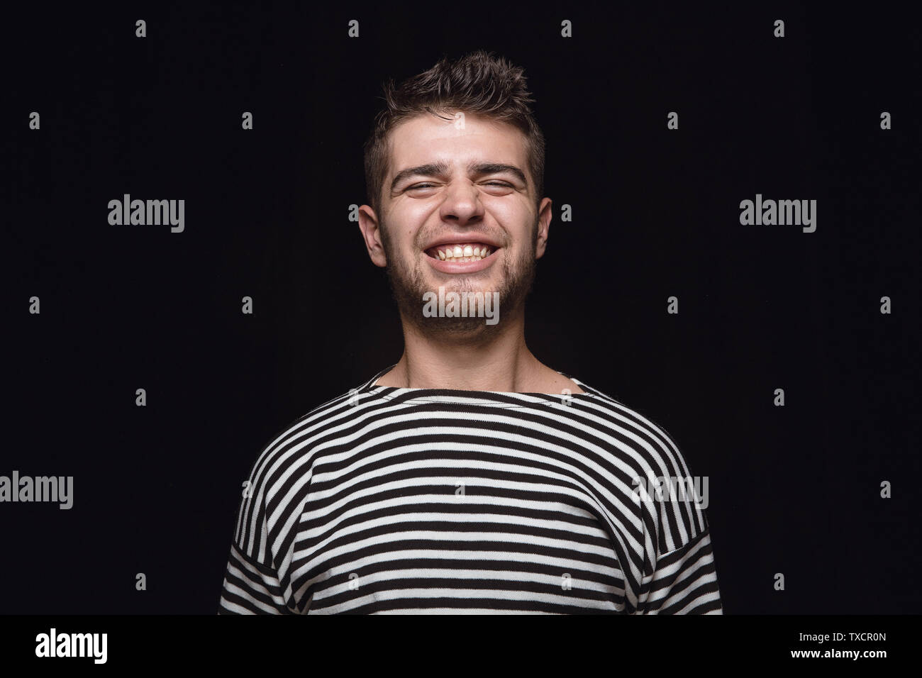 Close up portrait of young man isolated on black studio background ...
