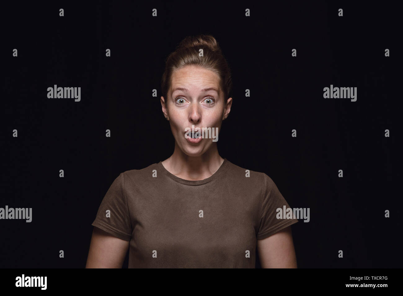 Close up portrait of young woman isolated on black studio background ...