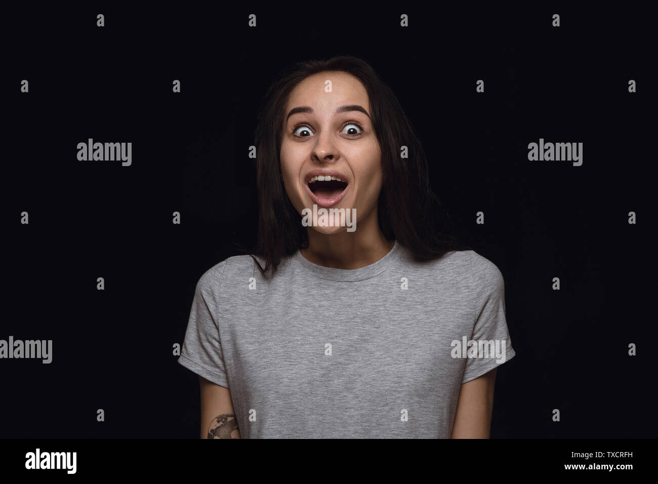 Close up portrait of young woman isolated on black studio background ...