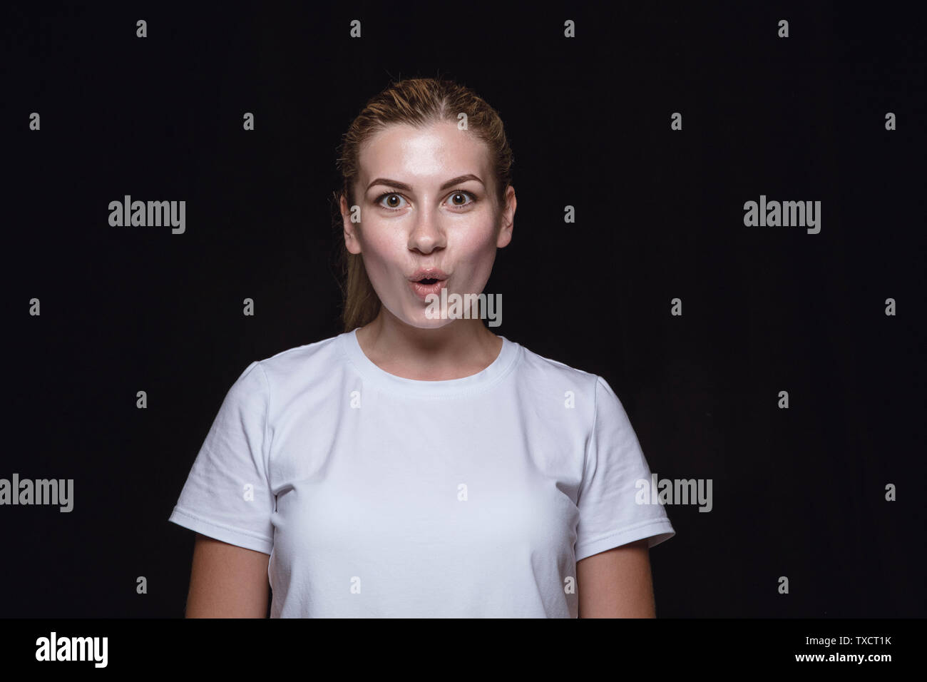 Close up portrait of young woman isolated on black studio background ...