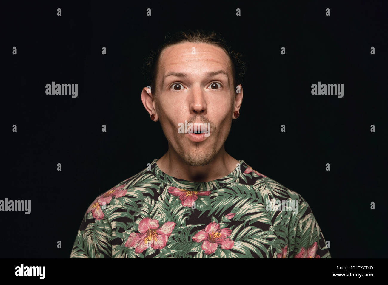 Close up portrait of young man isolated on black studio background ...