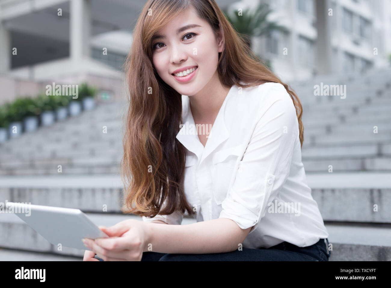 Asian female student using tablet in campus Stock Photo - Alamy