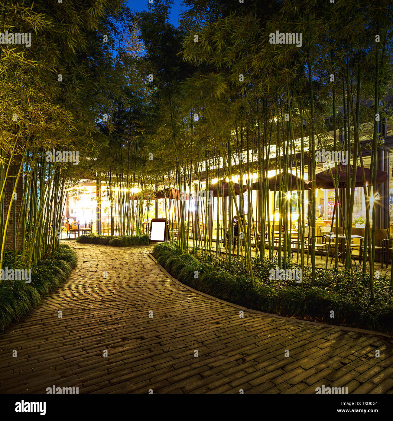 Illuminated restaurant with long footpath Stock Photo - Alamy