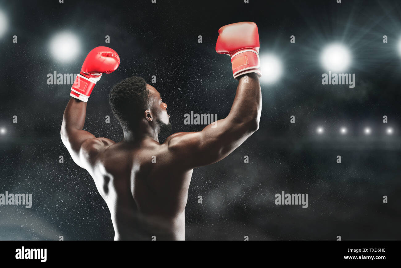 Fighter winner. African boxer raising his hands in boxing gloves ...