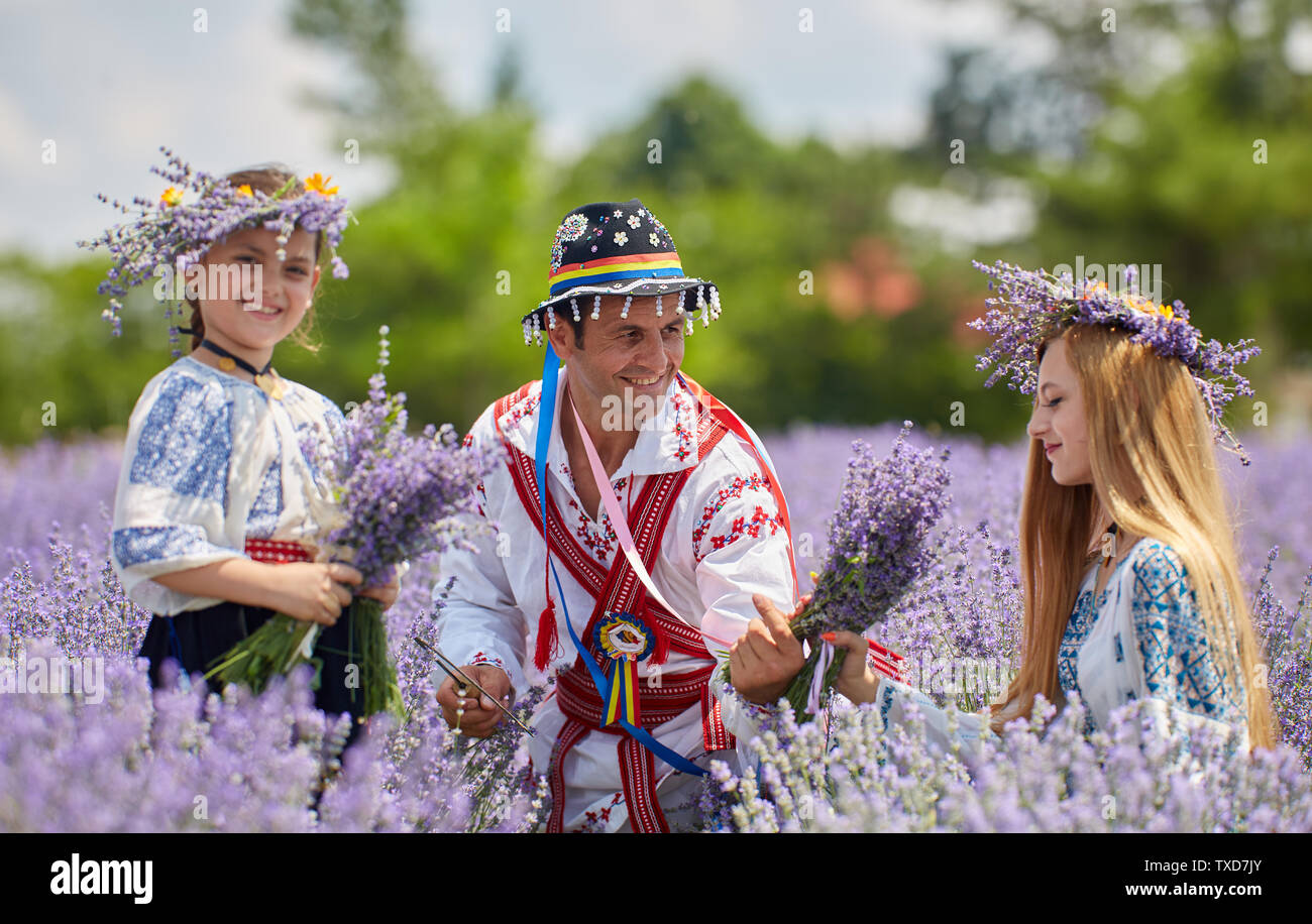 Family in traditional Romanian costume in lavender field Stock Photo ...