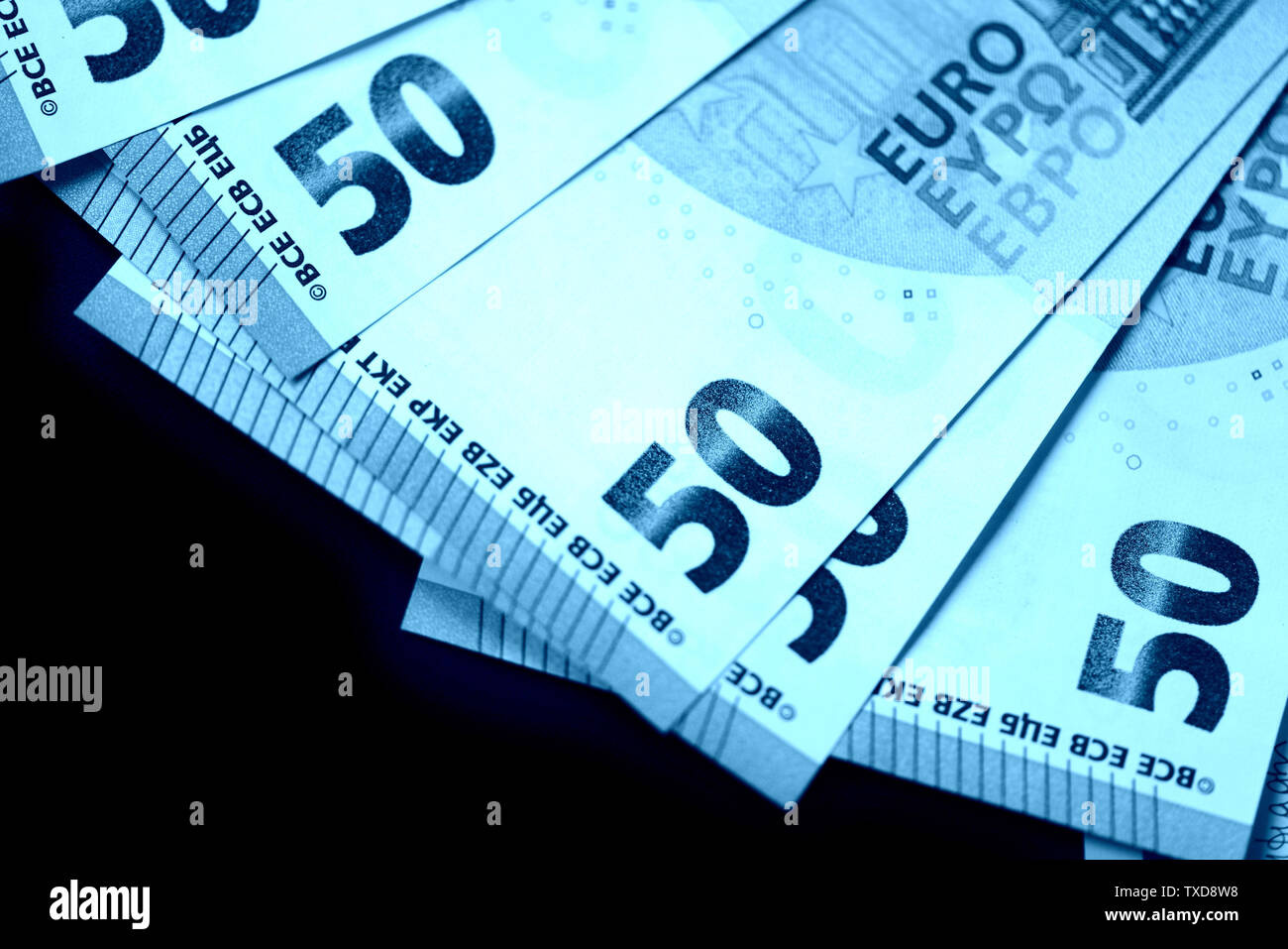 Fifty euro notes on a dark background close up. Blue color toned Stock ...
