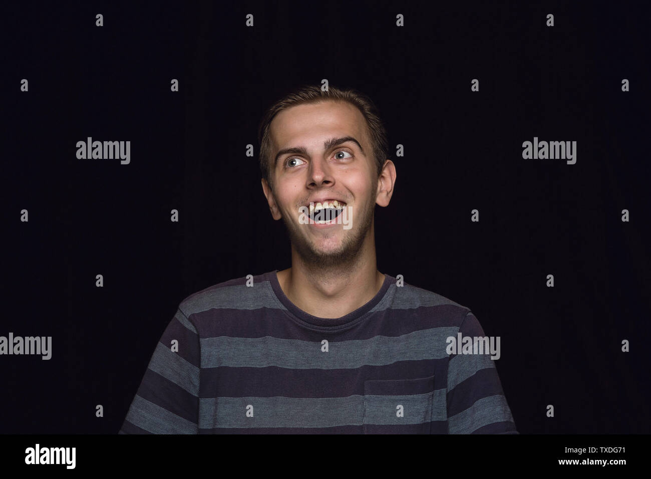 Close up portrait of young man isolated on black studio background ...