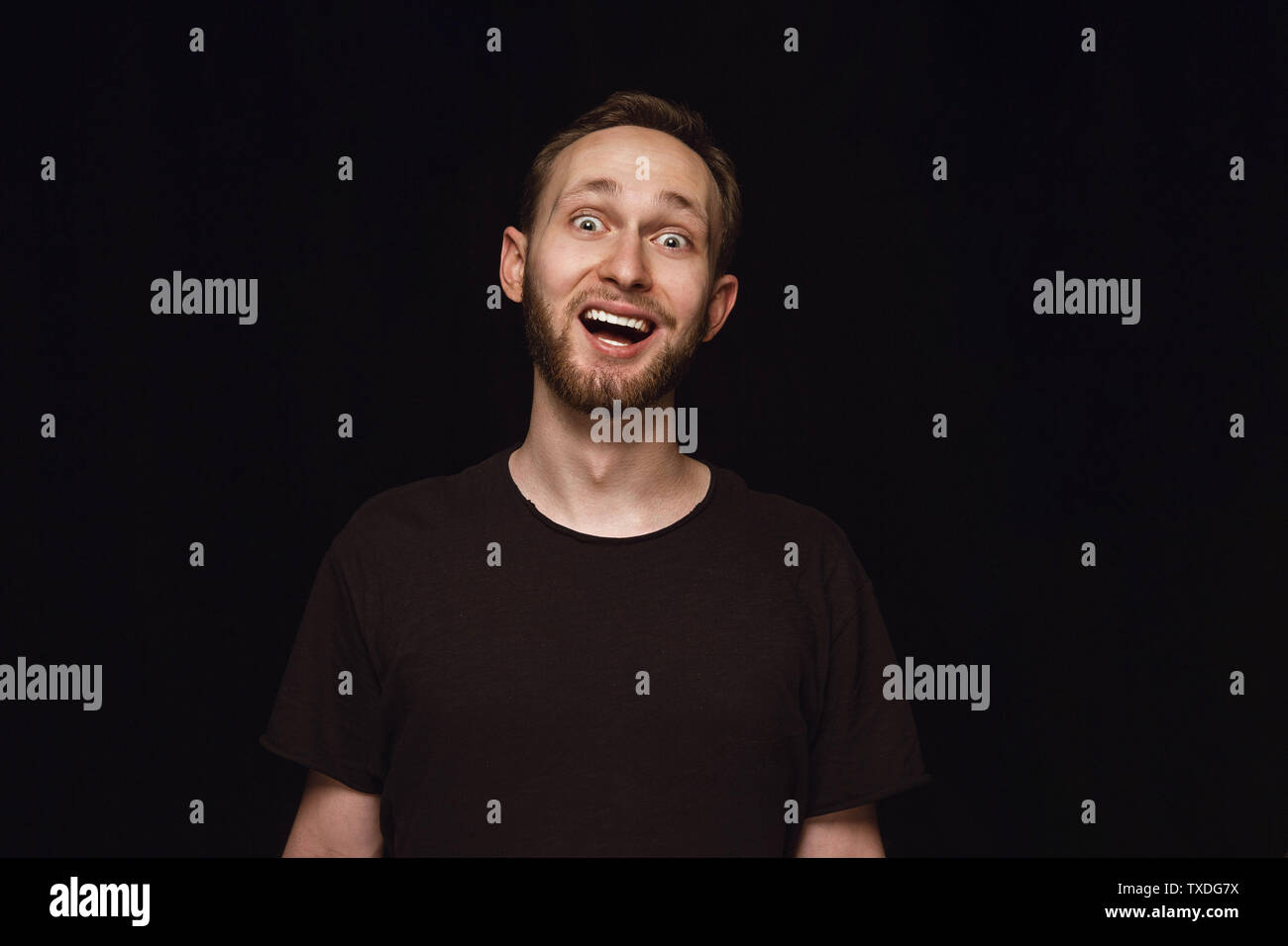 Close up portrait of young man isolated on black studio background ...