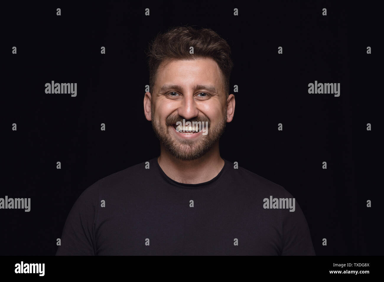 Close up portrait of young man isolated on black studio background ...