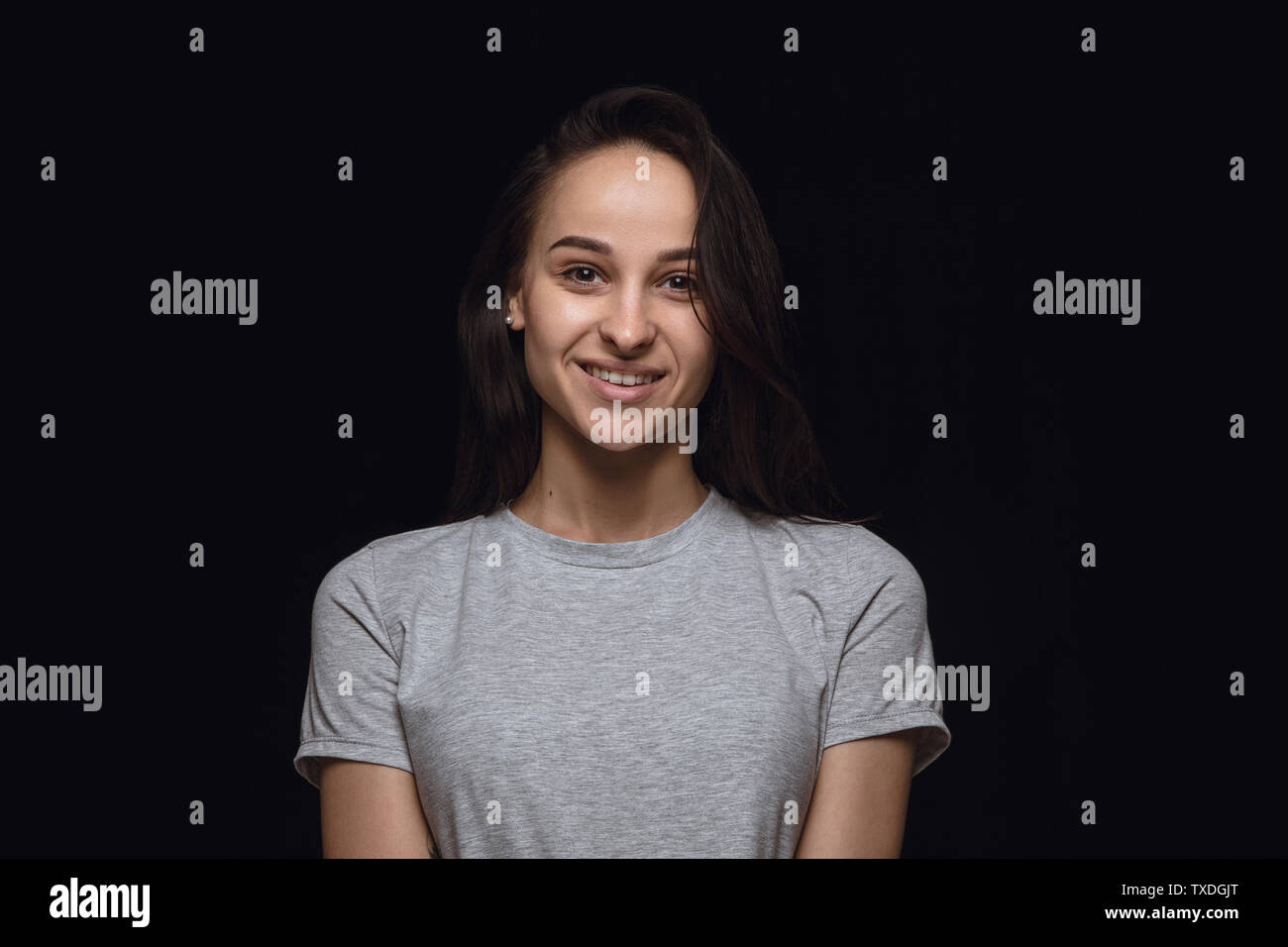 Close up portrait of young woman isolated on black studio background ...
