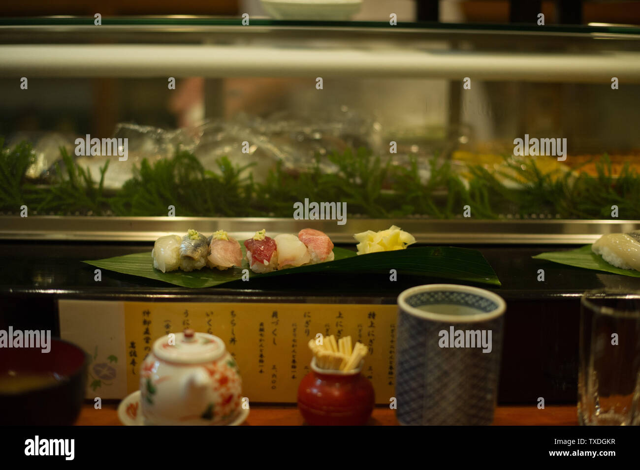 Food is prepared at a small Sushi restaurant at the Tsukiji Fish Market ...