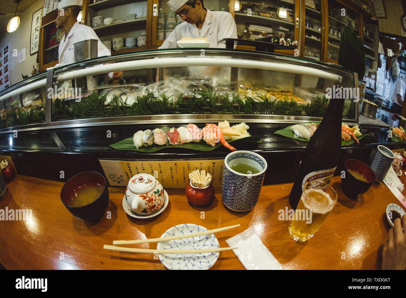 Food is prepared at a small Sushi restaurant at the Tsukiji Fish Market ...