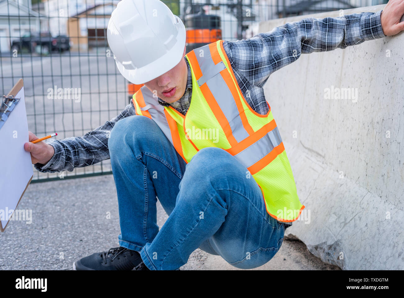 Upset and frustrated construction worker sitting down at a job site ...