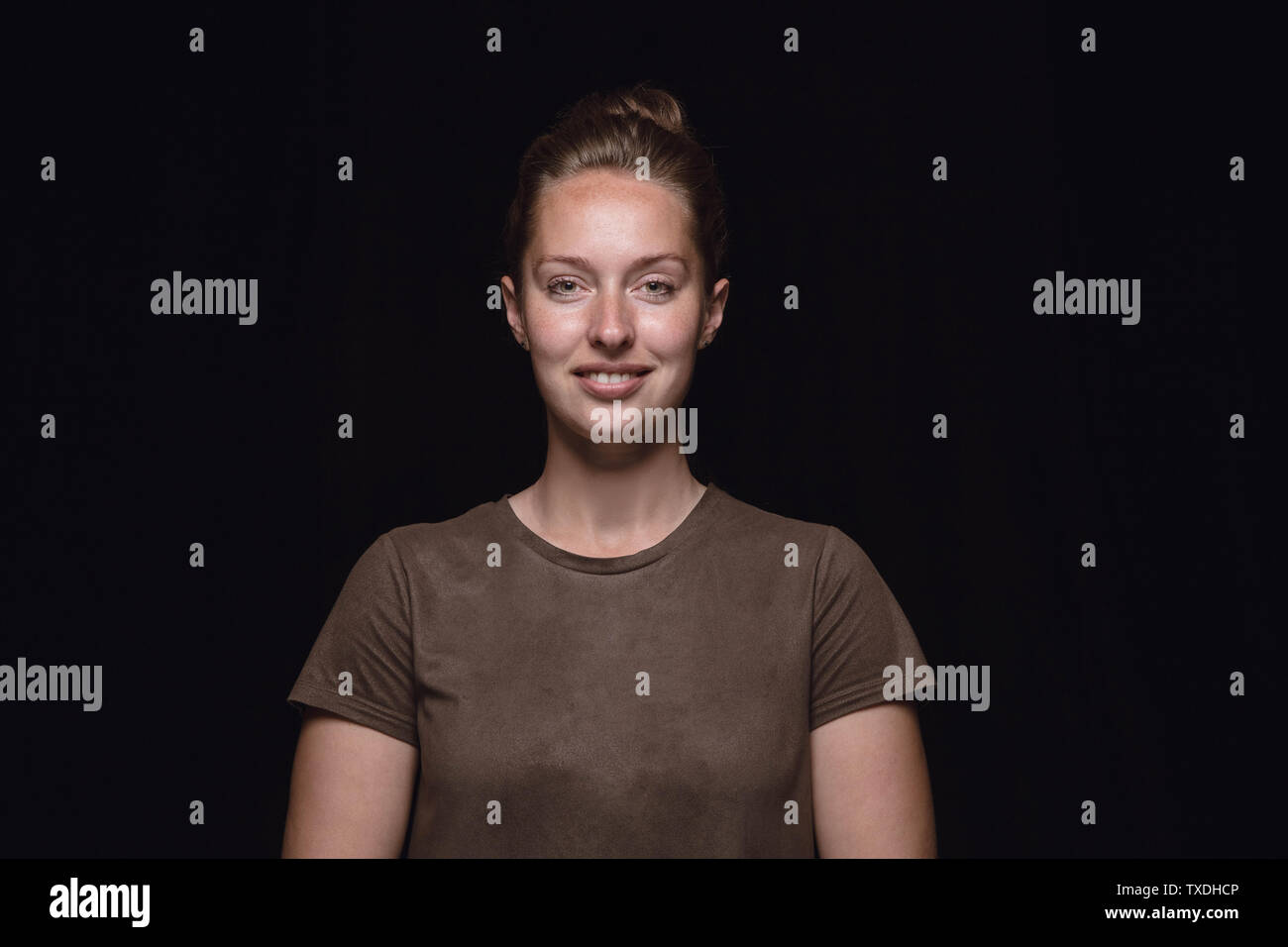 Close up portrait of young woman isolated on black studio background ...