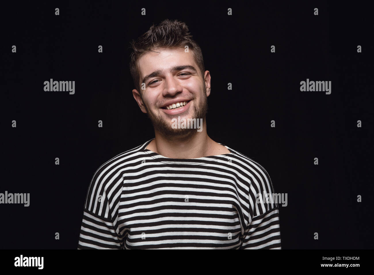 Close up portrait of young man isolated on black studio background ...