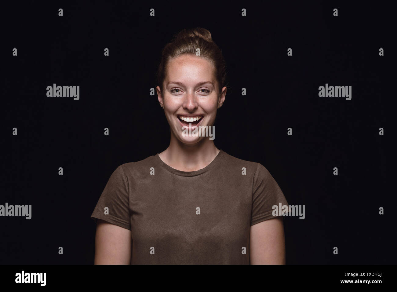 Close up portrait of young woman isolated on black studio background ...
