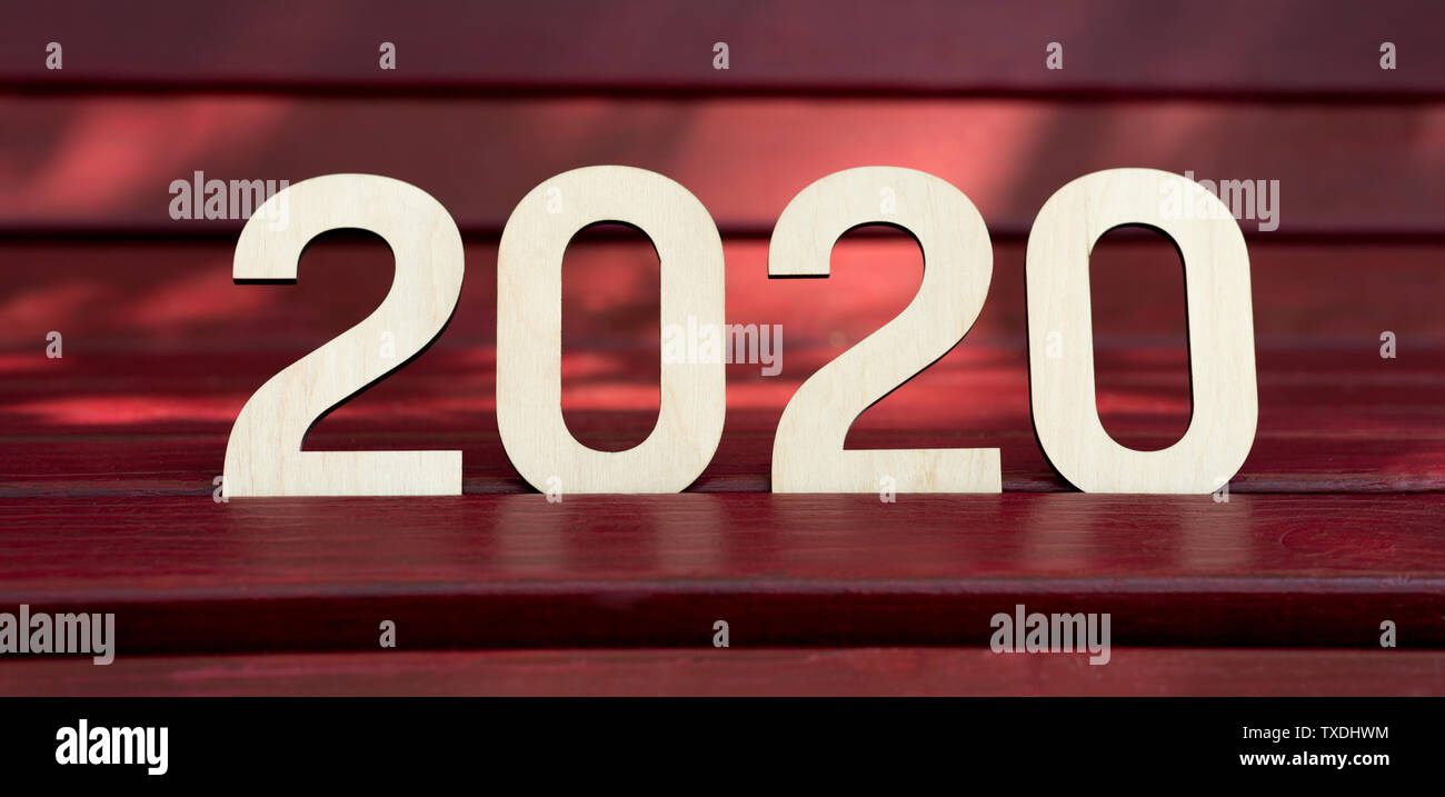 Close up of wooden 2020 numbers on burgundy bench in park in summer ...