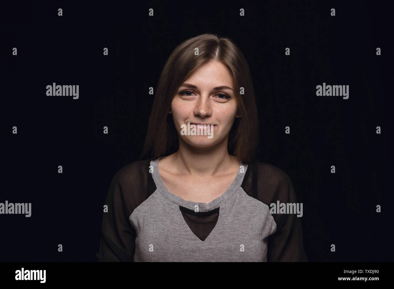 Close up portrait of young woman isolated on black studio background ...