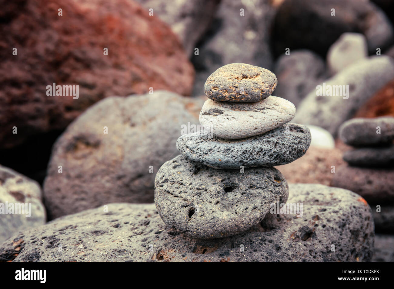 folded pyramid of smooth stones on the seashore, zen stone, symbol of ...