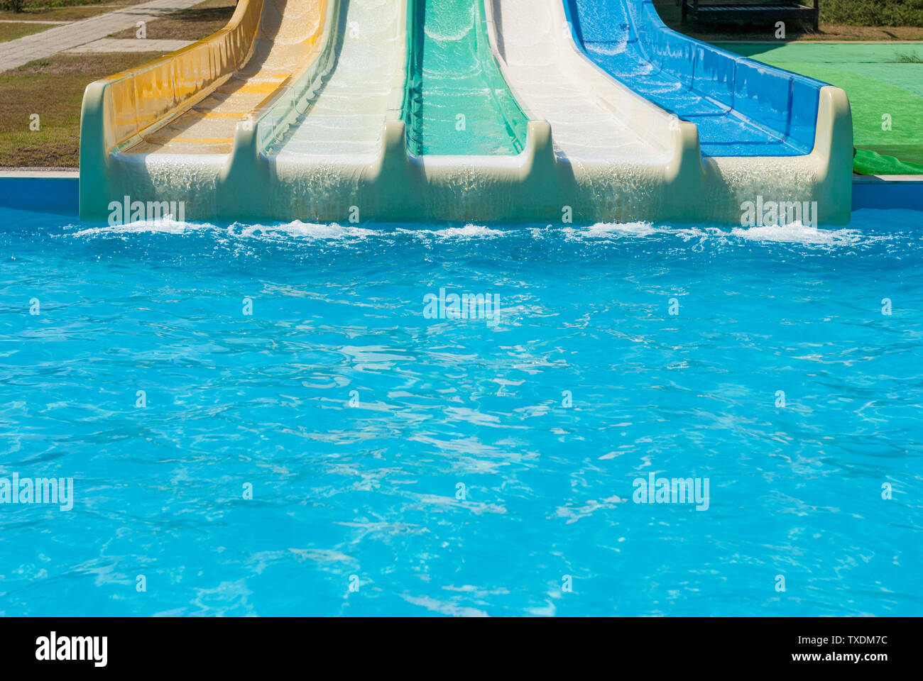 multicolored water slides with turquoise swimming pool in amusement ...