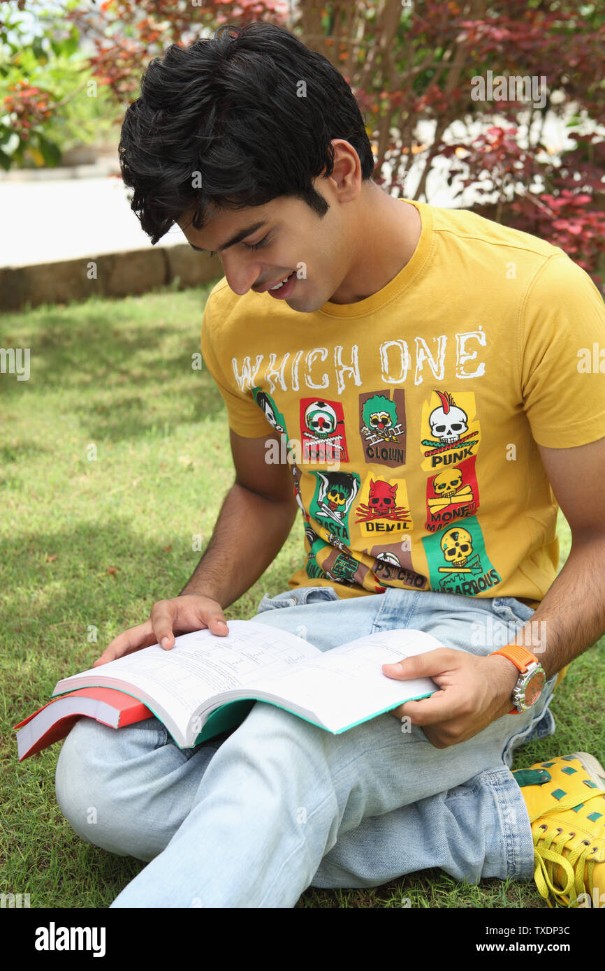 College student reading a book in the campus Stock Photo - Alamy