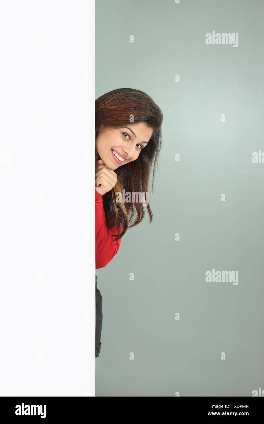 Woman hiding behind wall a watching hi-res stock photography and images ...