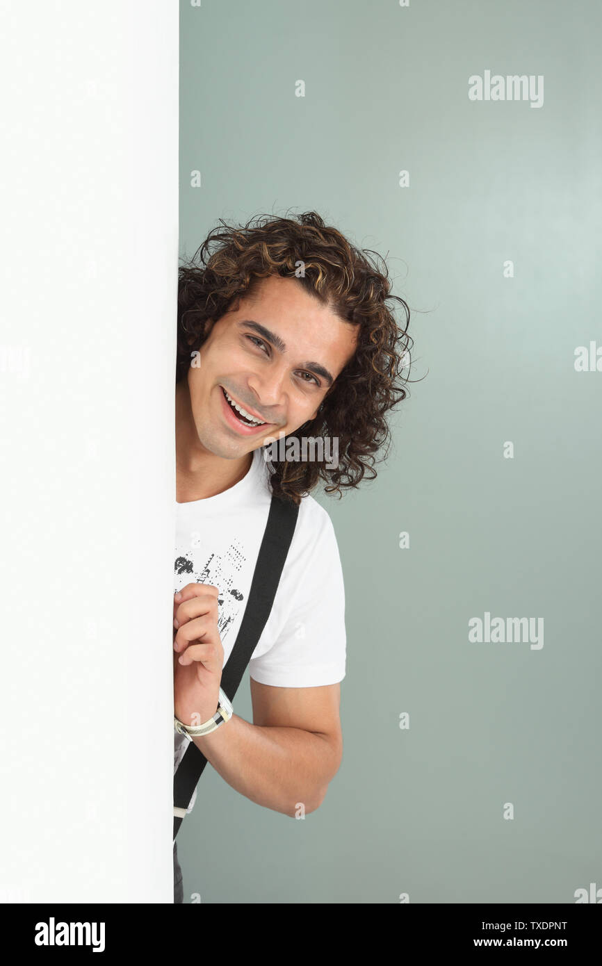 Portrait of a man hiding behind a placard and smiling Stock Photo - Alamy