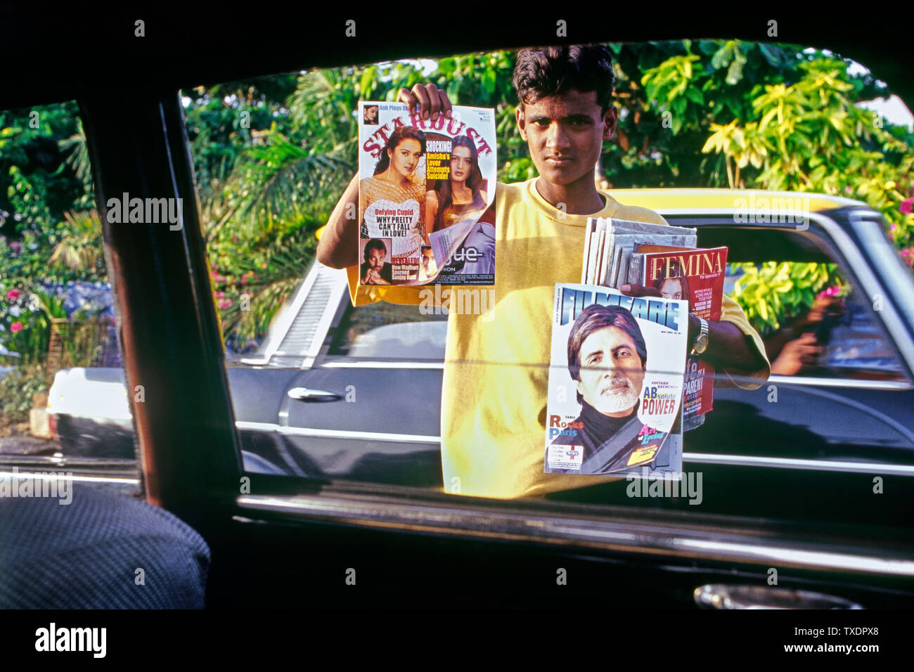 Boy selling Bollywood film magazines at traffic junction, Mumbai ...
