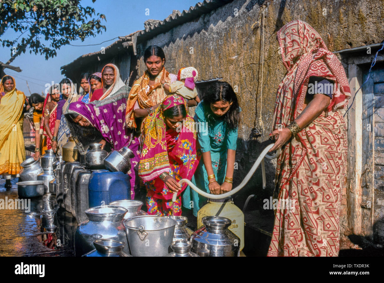 Women standing in queue to collect water in slum, Mumbai, Maharashtra ...