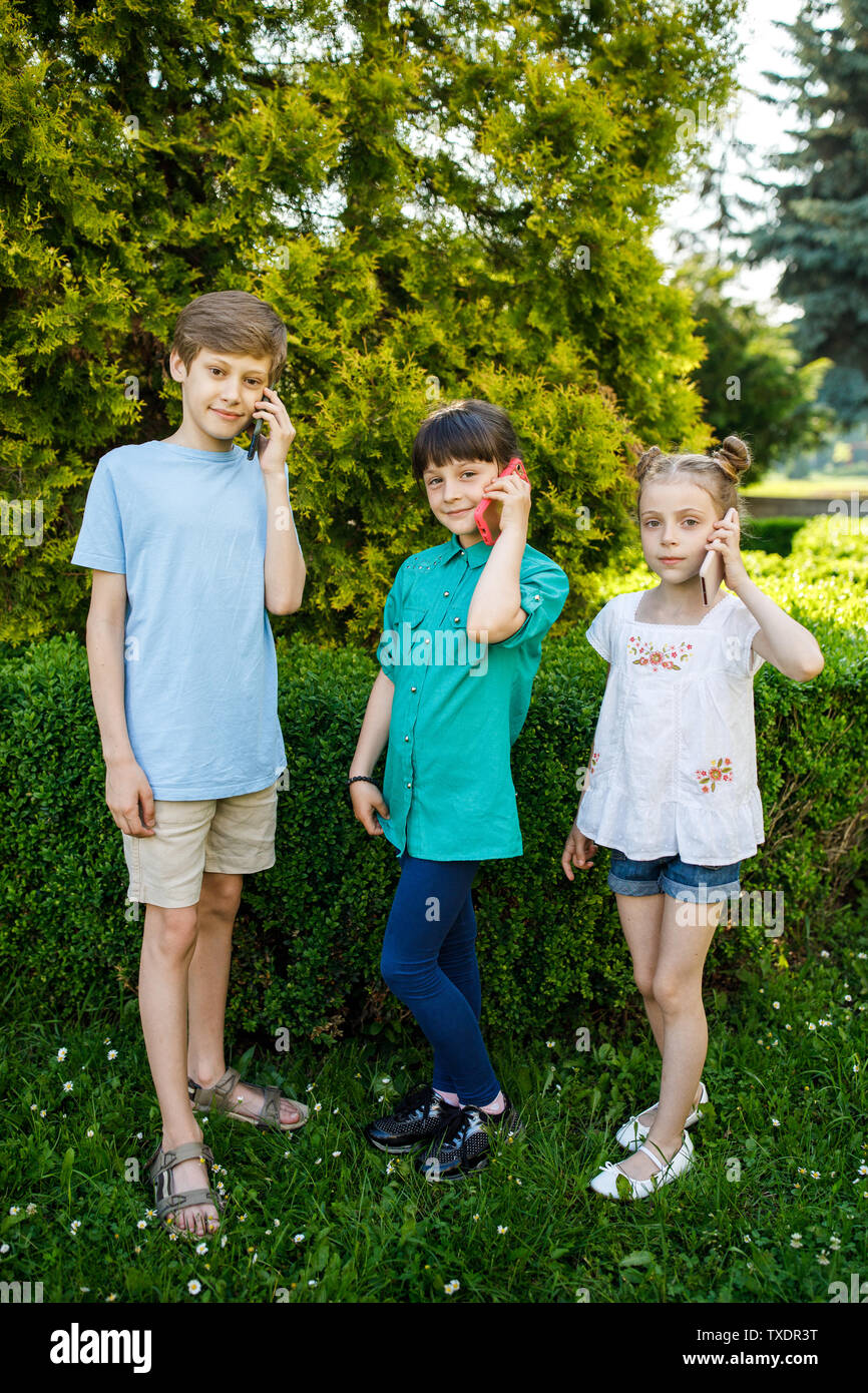 Three children talking hi-res stock photography and images - Alamy