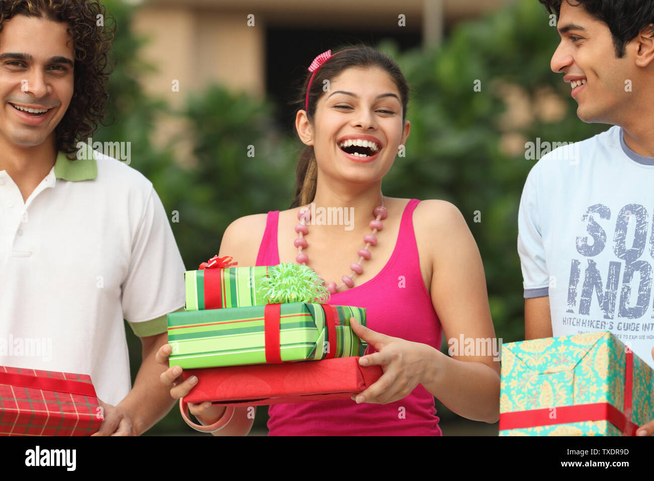 Three friends holding gifts Stock Photo - Alamy