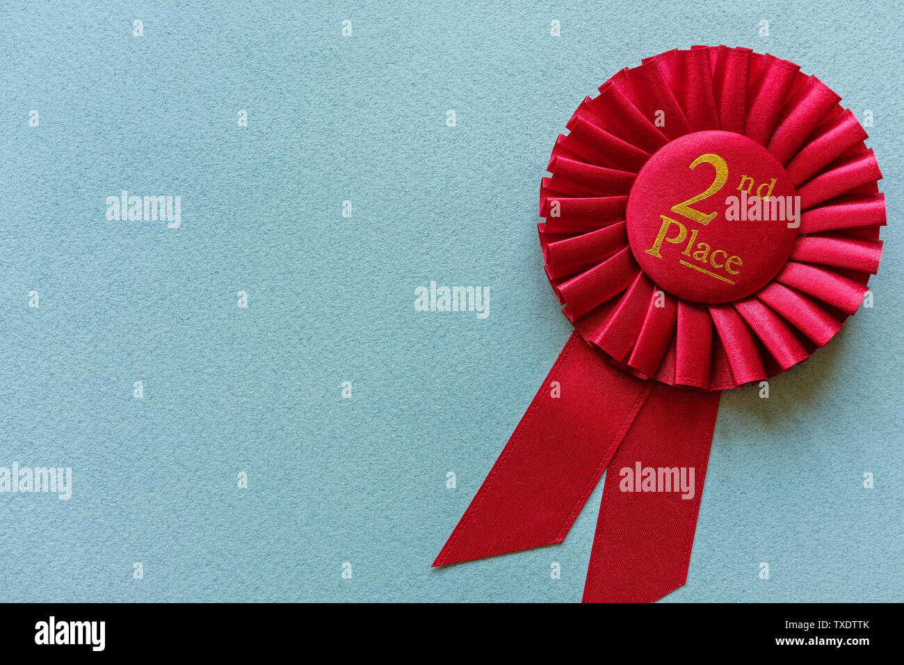 Red 2nd Place Winners rosette on light blue background with lateral ...
