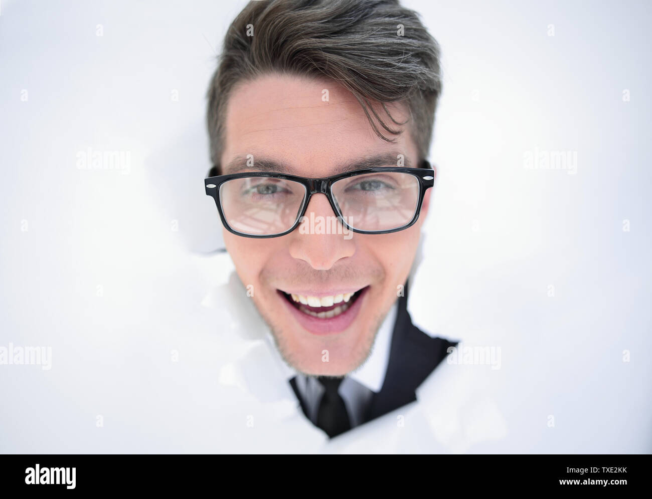 young businessman breaking through a white paper wall Stock Photo - Alamy