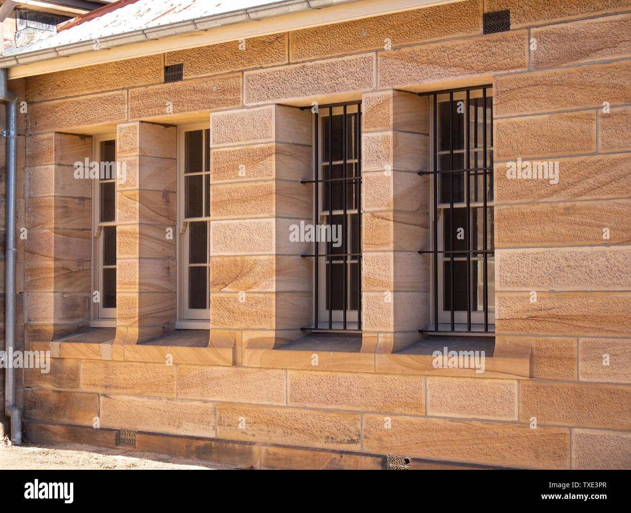 Sandstone convict brick made building close up of large tall windows ...