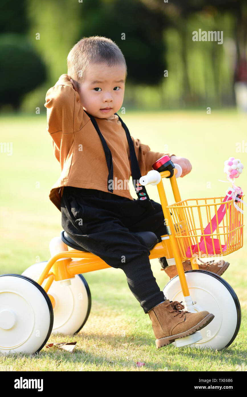 Little boy riding a tricycle Stock Photo - Alamy