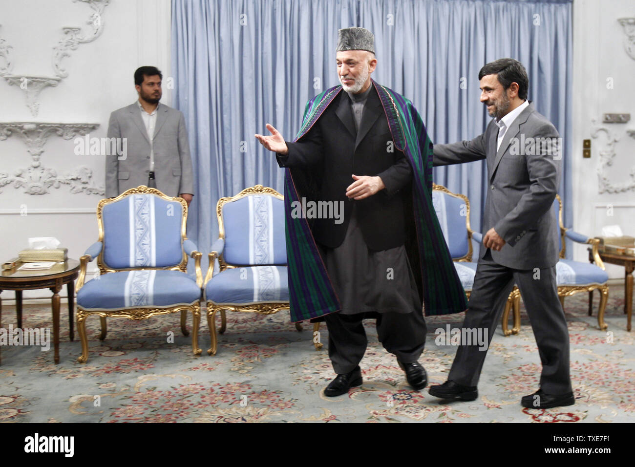 Iranian President Mahmoud Ahmadinejad (R) greets Afghan president Hamid ...