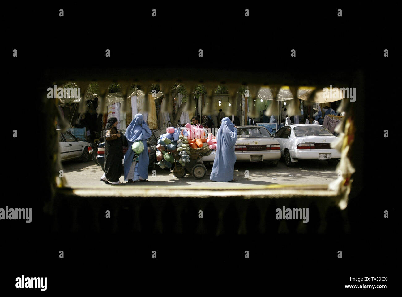 Two burqa-clad Afghan women are seen from a rickshaw window as they ...