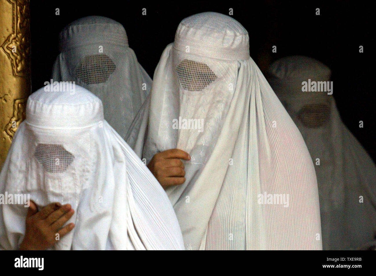White Burqa-clad women leave the Blue Mosque after prayers in Mazar-e ...