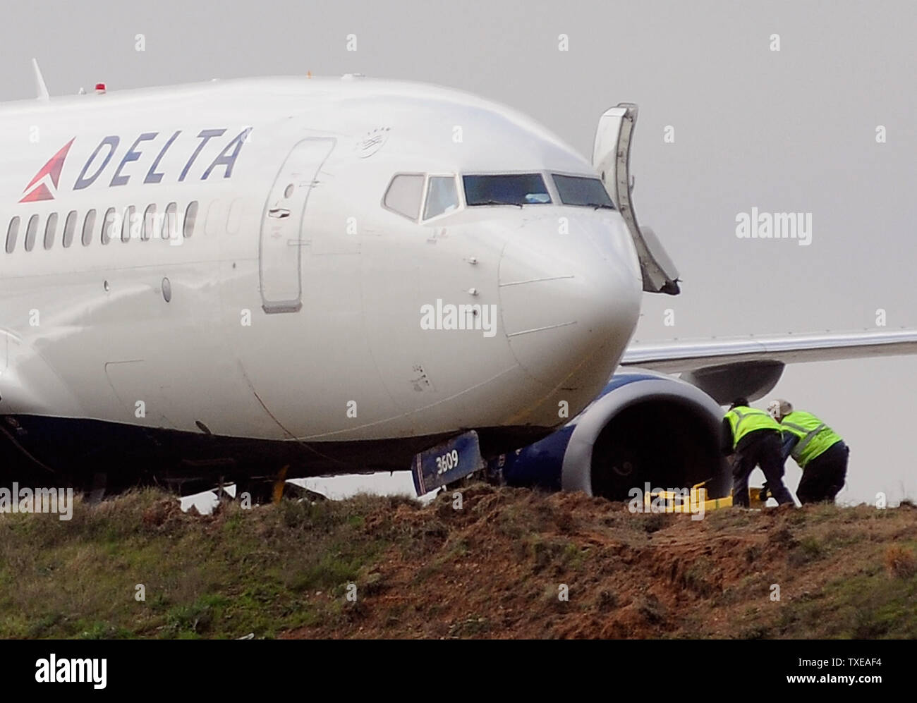 Workers prepare to tow a Delta jet back to the ramp after the Boeing ...