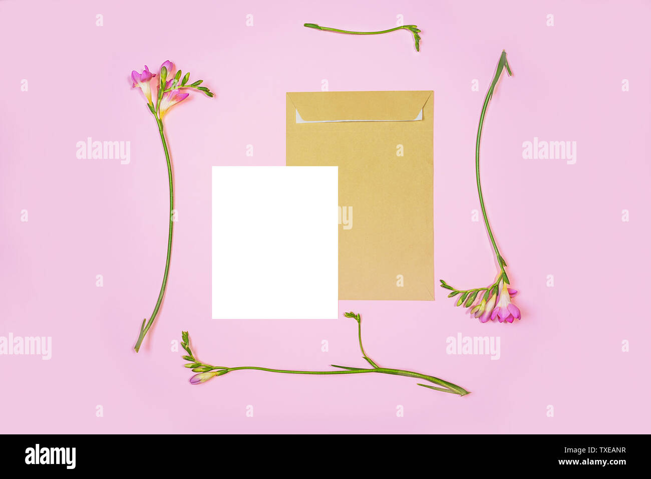 Flat lay shot of white letter sheet and eco paper envelope on pink ...