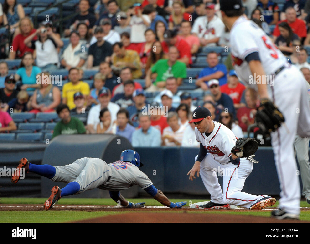 New York Mets left fielder Eric Young Jr. (L) is held on first base by ...